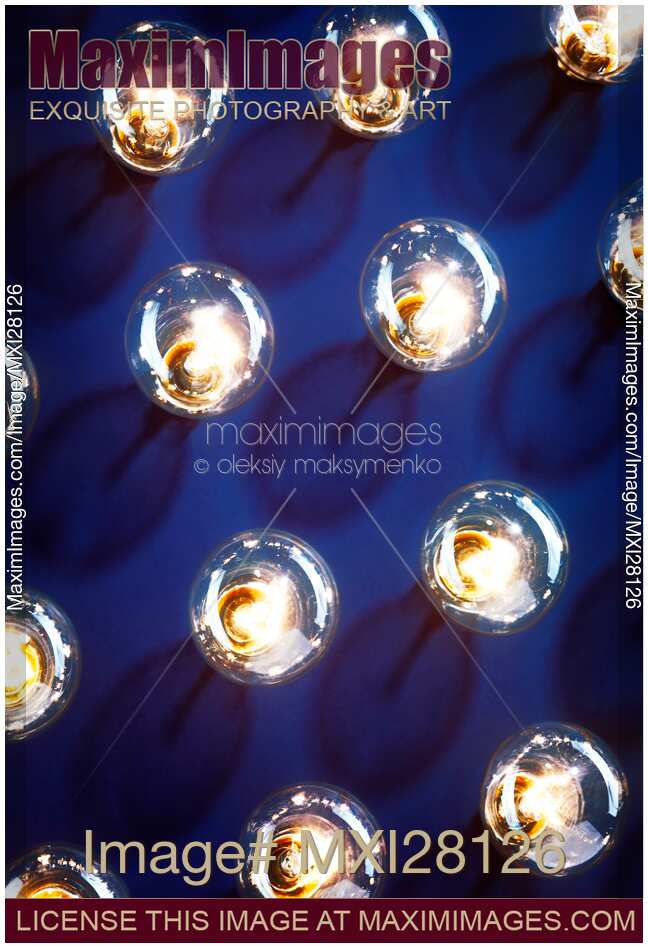 Photo of Lit light bulbs on blue background | Stock Image MXI28126