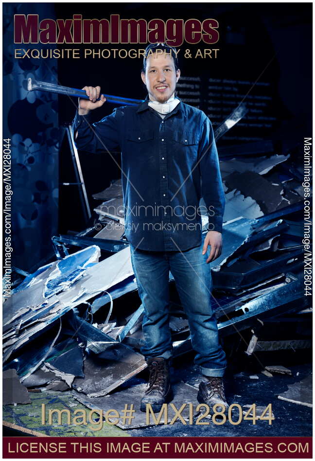 Photo of Portrait of man with sledgehammer at demolition work | Stock ...