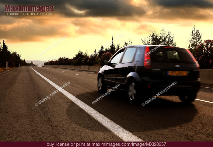 Car driving by highway at sunset. Stock Photo MXI20257