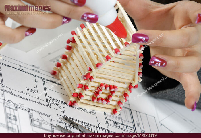 Woman Building a House from Matches. Stock Photo MXI20419