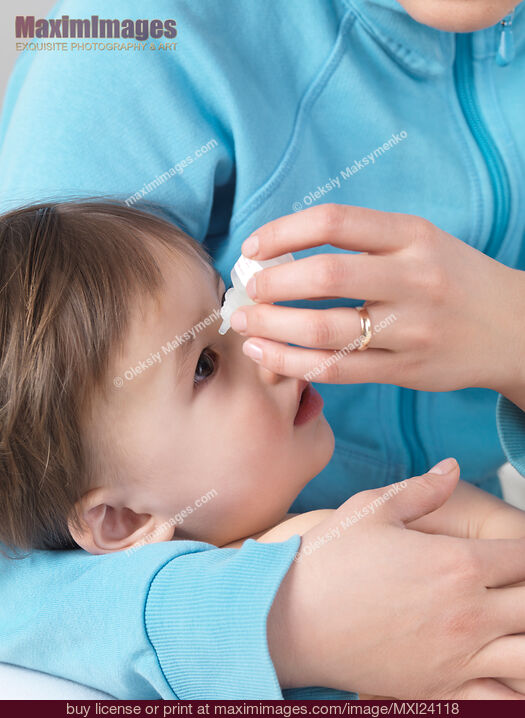 Nother giving baby eye drops. Stock Photo MXI24118