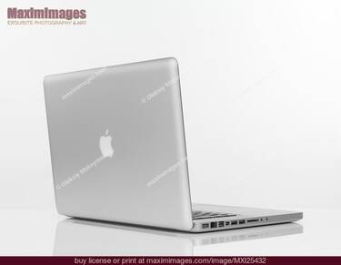 Macbook Pro laptop with Apple logo on the lid. Stock Photo MXI25432