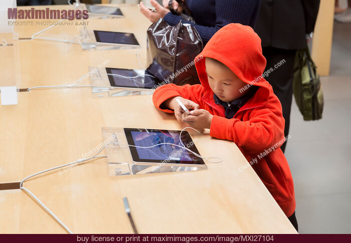 Child using iPhone at Apple store. Stock Photo MXI27104
