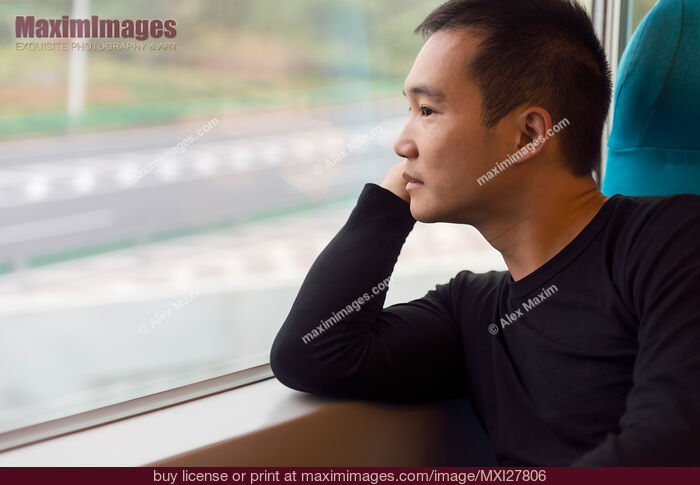 Person looking out of a window of a high-speed train. Stock Photo MXI27806