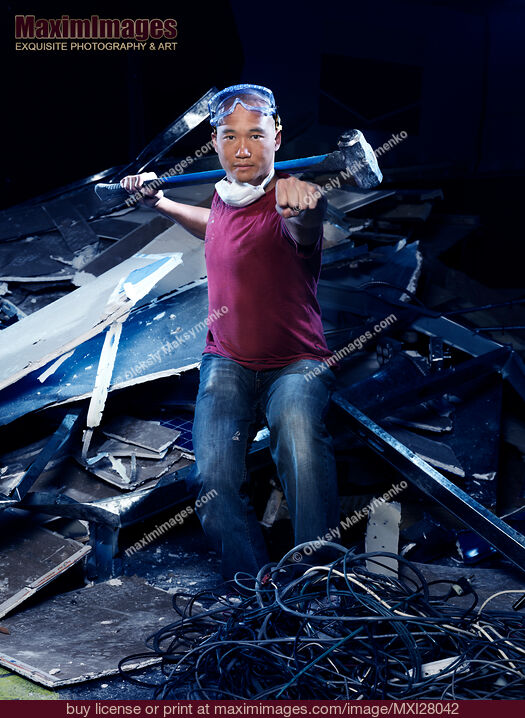 Portrait of man in Kung Fu stance with sledgehammer at demolition work ...