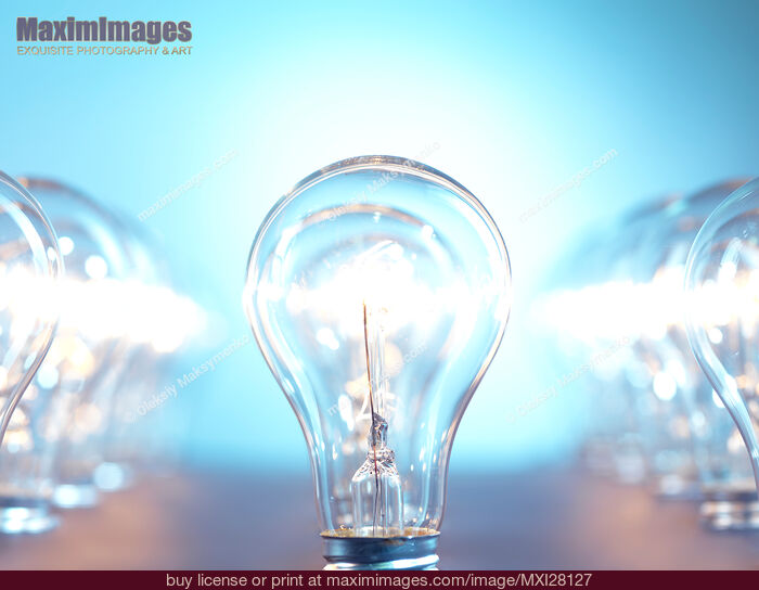 Illuminated light bulbs on bright blue background. Stock Photo MXI28127