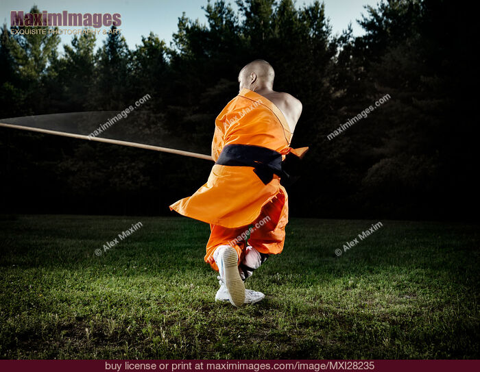Shaolin warrior monk spinning with a staff. Stock Photo MXI28235