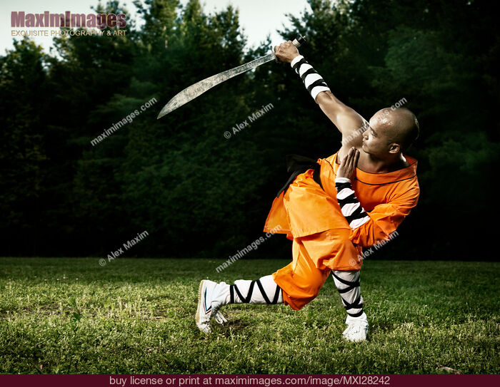 Monk practicing Shaolin broad sword outdoors. Stock Photo MXI28242