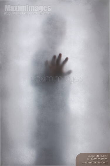 Photo of Ghostly mysterious man touching glass barrier with his hand ...