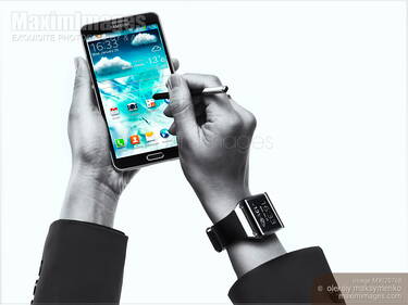 Photo of Person with Samsung Galaxy Note III smartphone and Galaxy Gear ...