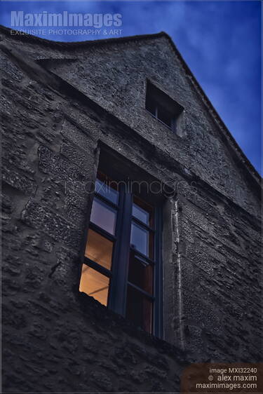 Photo of Shut window of an old European house at night illuminated from ...