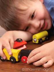 Photo of Smiling young boy plaing with a toy train | Stock Image MXI24349
