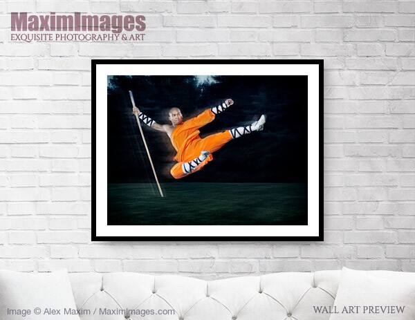 Art Print of Shaolin warrior monk performing flying kick with a staff ...
