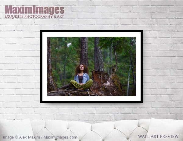 Art Print of Young woman resting meditating in forest sitting against ...